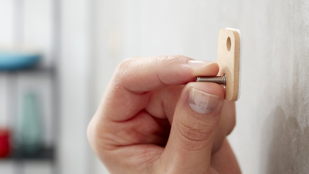Attaching a small bookshelf without drilling - tesa